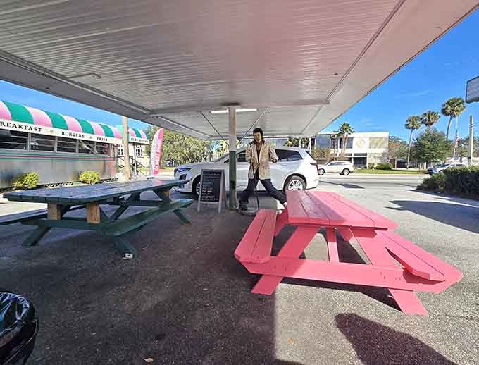 Outdoor seating with a life-size vintage server statue means even the parking lot commits to the nostalgic theme.