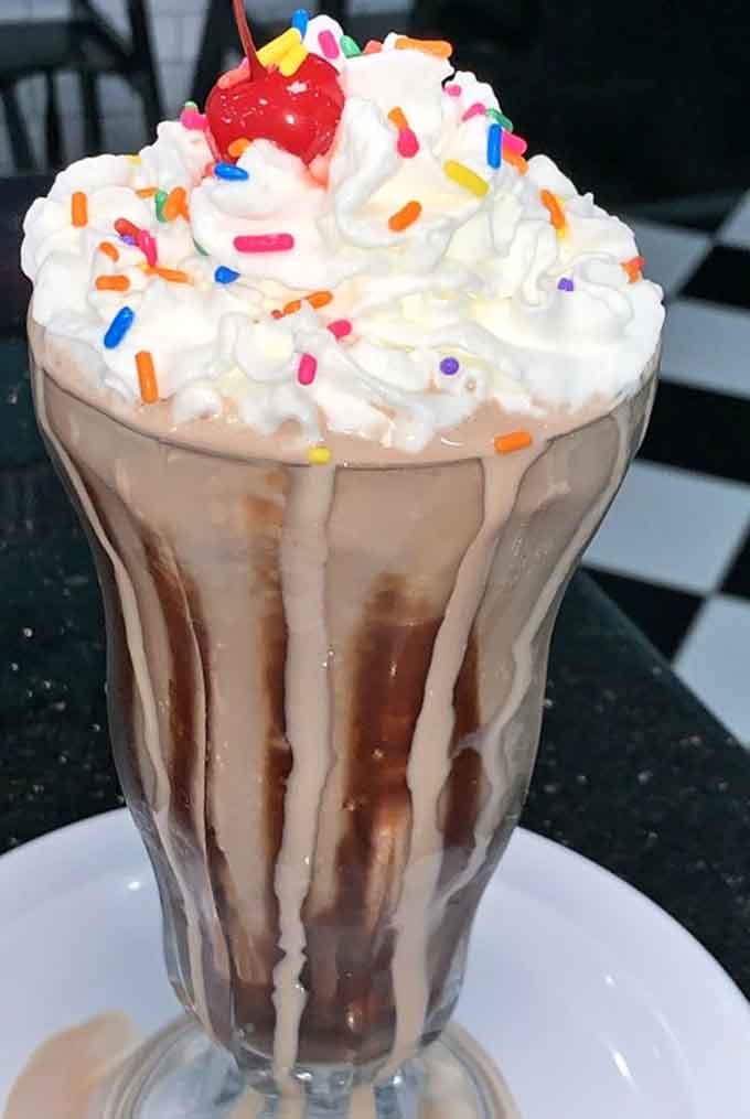 This milkshake topped with whipped cream and sprinkles is basically childhood in a glass, and nobody's too old for that.