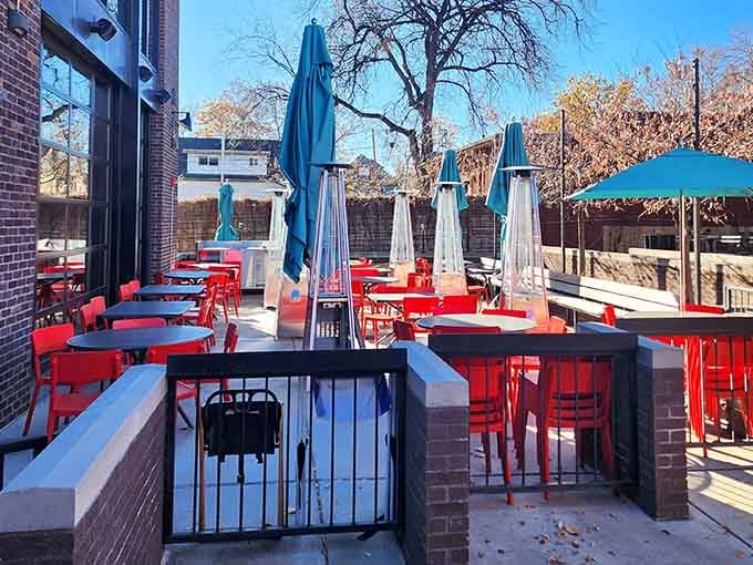 Outdoor seating with bright red tables where Denver sunshine and bacon aromas create the perfect weekend morning combination.