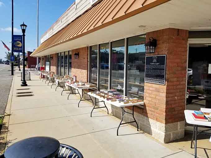 Books displayed on outdoor tables under that awning invite passersby to stop, browse, and maybe discover something they didn't know they needed.