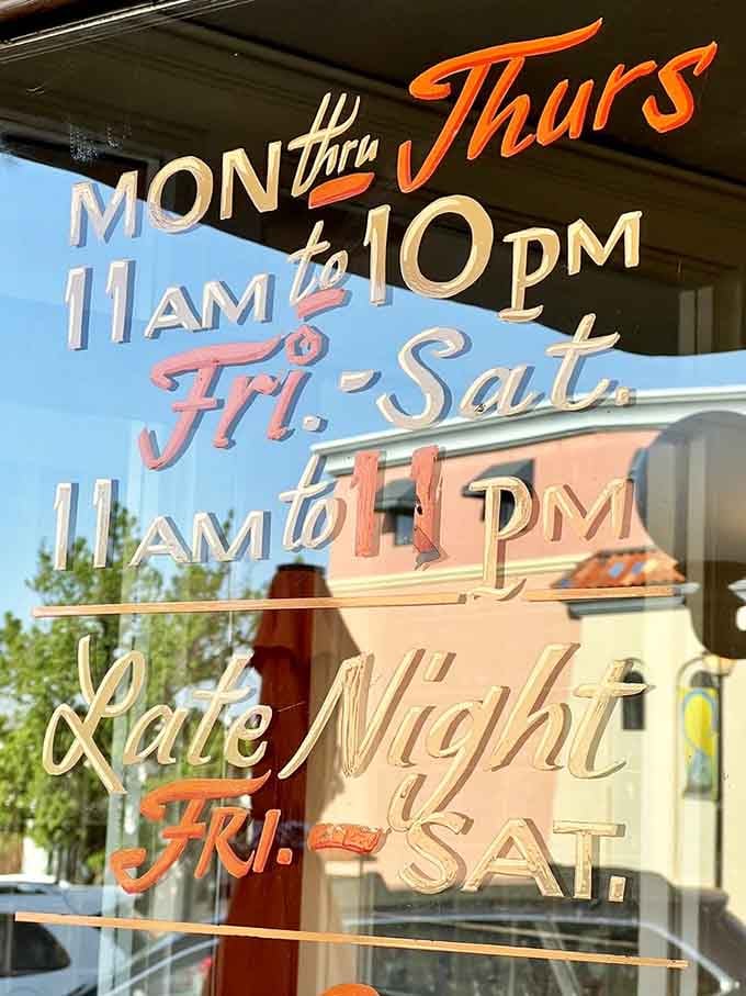 Those hand-painted business hours tell you everything about Picasso Cafe's personality—artistic, precise, and staying up late on weekends.