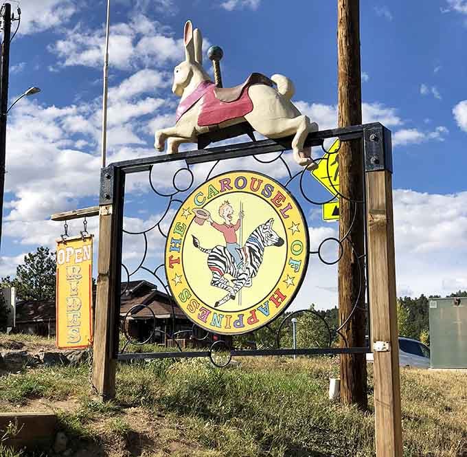 A hand-carved bunny tops the roadside sign, beckoning travelers to discover what happiness looks like when it spins.