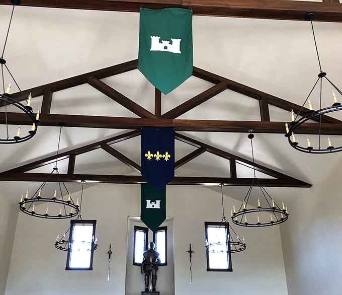 Soaring ceilings adorned with heraldic banners and exposed beams create an atmosphere of genuine medieval grandeur throughout.