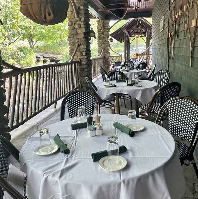 Outdoor seating where the forest becomes your dining companion, proving nature pairs perfectly with white tablecloths and good food.