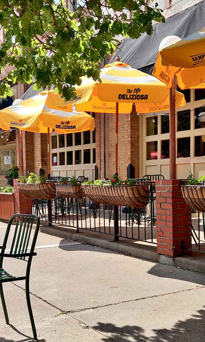 Sunny outdoor seating under cheerful yellow umbrellas where you can watch downtown Bloomington while enjoying your meal alfresco style.