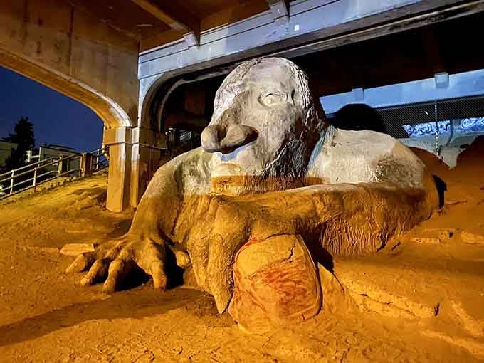 At night, the troll takes on an even more mysterious quality under the bridge's ambient lighting.