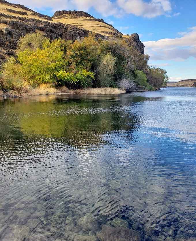 Crystal-clear waters reflecting cliffs and sky, creating a mirror image that doubles the beauty in every direction.