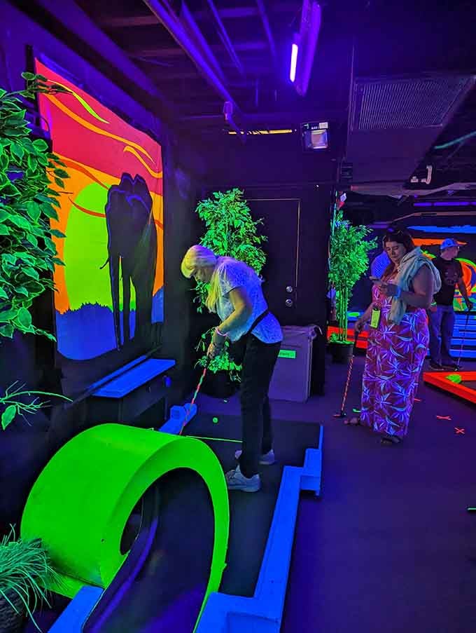 Families navigate the glowing course together, creating memories that shine as brightly as the fluorescent paint surrounding them.