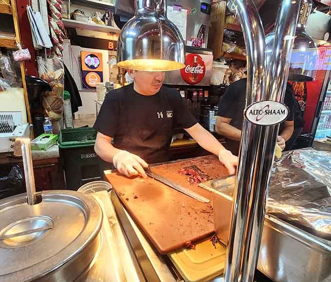 Slicing pastrami with the precision of a surgeon and the confidence of someone who's done this forever.