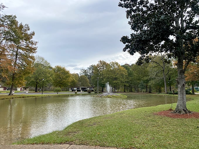 Highland Park's serene pond reflects autumn trees and cloudy skies, creating a postcard-perfect scene in this historic community gathering place.