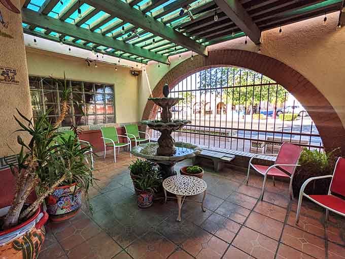 The charming outdoor patio offers a peaceful spot to wait, complete with fountain and the promise of incredible food ahead.