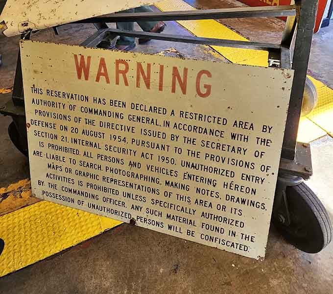 This warning sign means business, reminding visitors that unauthorized entry once carried consequences beyond a stern talking-to.