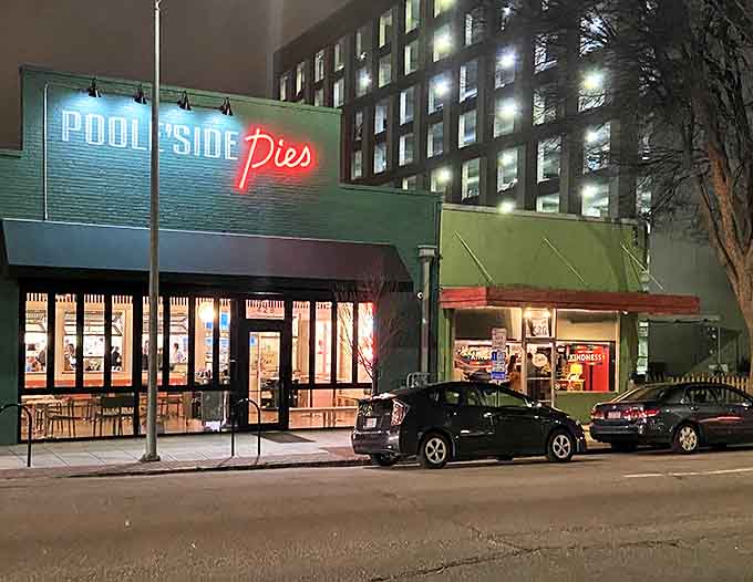 That neon "Pies" sign glowing at night is basically a lighthouse guiding hungry souls to their cheesy salvation.