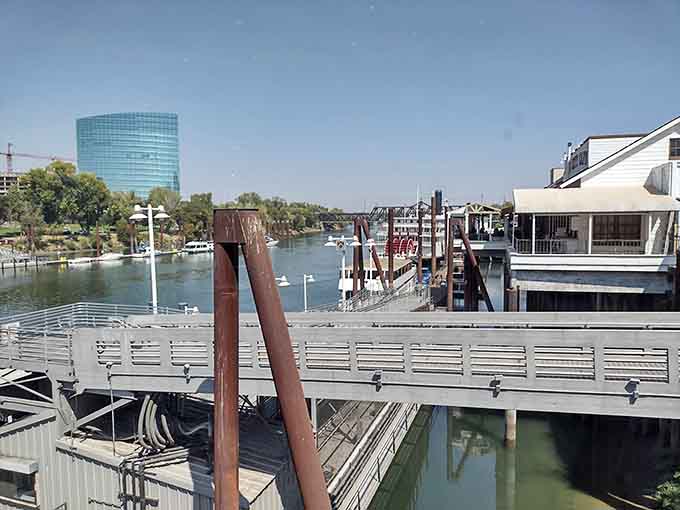 The waterfront walkway offers front-row seats to river life, where boats and buildings share the stage with natural beauty.