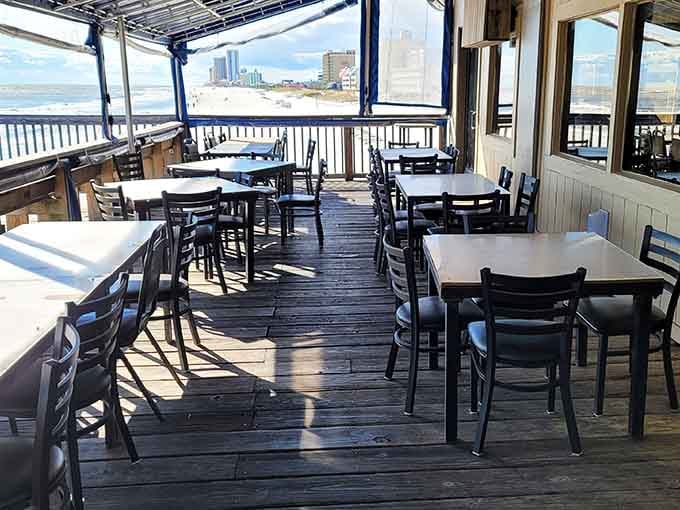 Empty outdoor deck seating waiting for the next wave of hungry beachgoers, like a stage before the show begins.