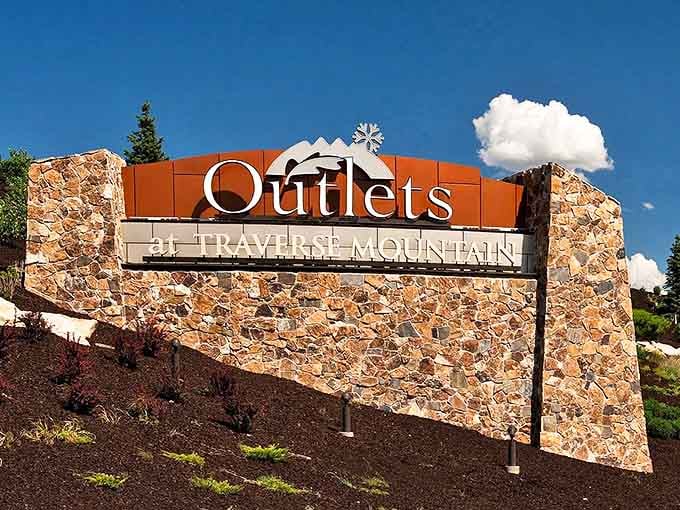 The grand entrance sign stands like a retail monument against Utah's blue sky. Your wallet may be lighter when you leave, but your shopping bags won't be.
