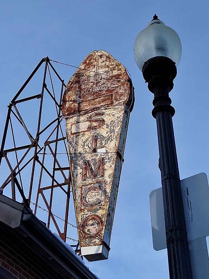 The weathered hot dog sign standing tall above the restaurant, a beacon of hope for the hungry and weary traveler.