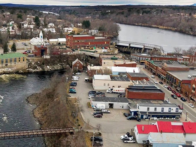 From above, Skowhegan reveals its perfect positioning along the Kennebec River, where downtown buildings cluster near the water that shaped the town's destiny.