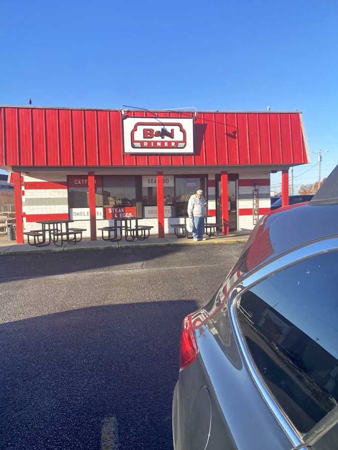 Morning sunshine hitting that red exterior just right&mdash;like the diner is literally glowing with breakfast potential. Your stomach is already saying "thank you."