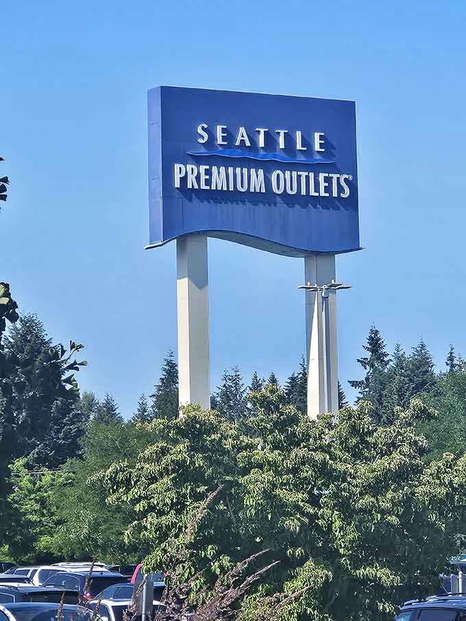 The iconic blue sign rises above the trees like a retail lighthouse, guiding deal-seekers safely to discount shores.