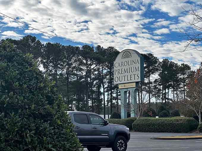 The welcoming signage promises deals ahead, like a treasure map leading to discounted designer goods and happy credit cards.