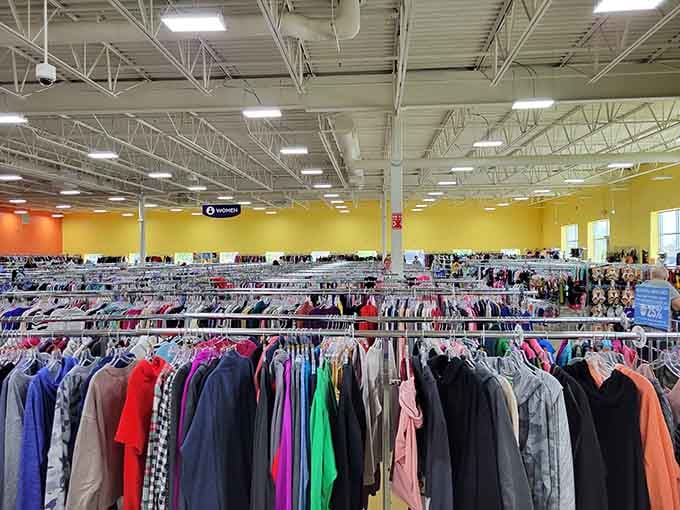 Those cheerful yellow walls and endless clothing racks create a treasure hunter's paradise under bright warehouse lights.