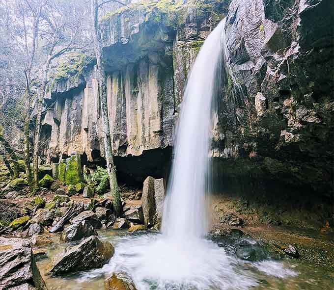 Those golden icicle formations hanging above the waterfall look like nature's own chandelier lighting up this hidden grotto.