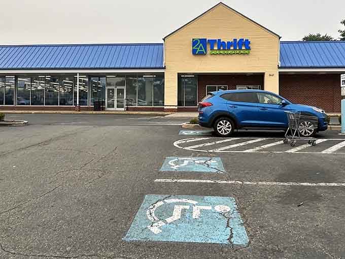The blue metal roof gleams under cloudy skies while painted parking spots guide bargain hunters to their destiny.