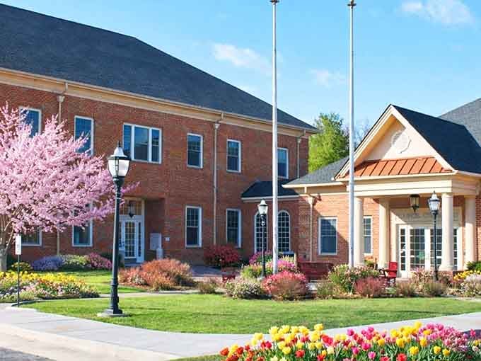 Spring blooms frame this welcoming civic building like nature's own picture frame, perfectly composed and inviting.