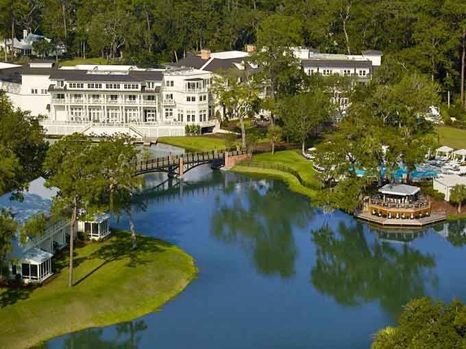 Waterfront elegance meets Lowcountry charm where grand architecture reflects perfectly in still waters below.