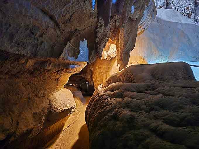 Golden stone flows like frozen caramel down massive cave walls, creating an underground palace worth the mountain drive.