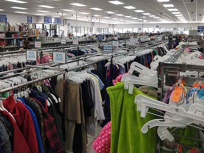 Rows of colorful clothing stretch endlessly under bright lights, creating a rainbow of secondhand possibilities.