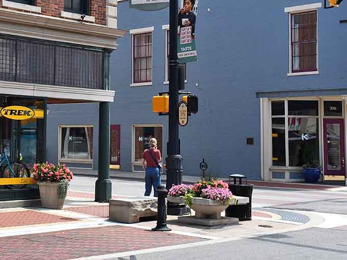Fresh flowers brighten the brick-paved streets where locals stroll past charming shops on sunny afternoons.