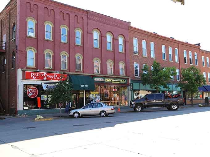 Red brick buildings line the street with architectural details that remind you craftsmanship used to mean something.