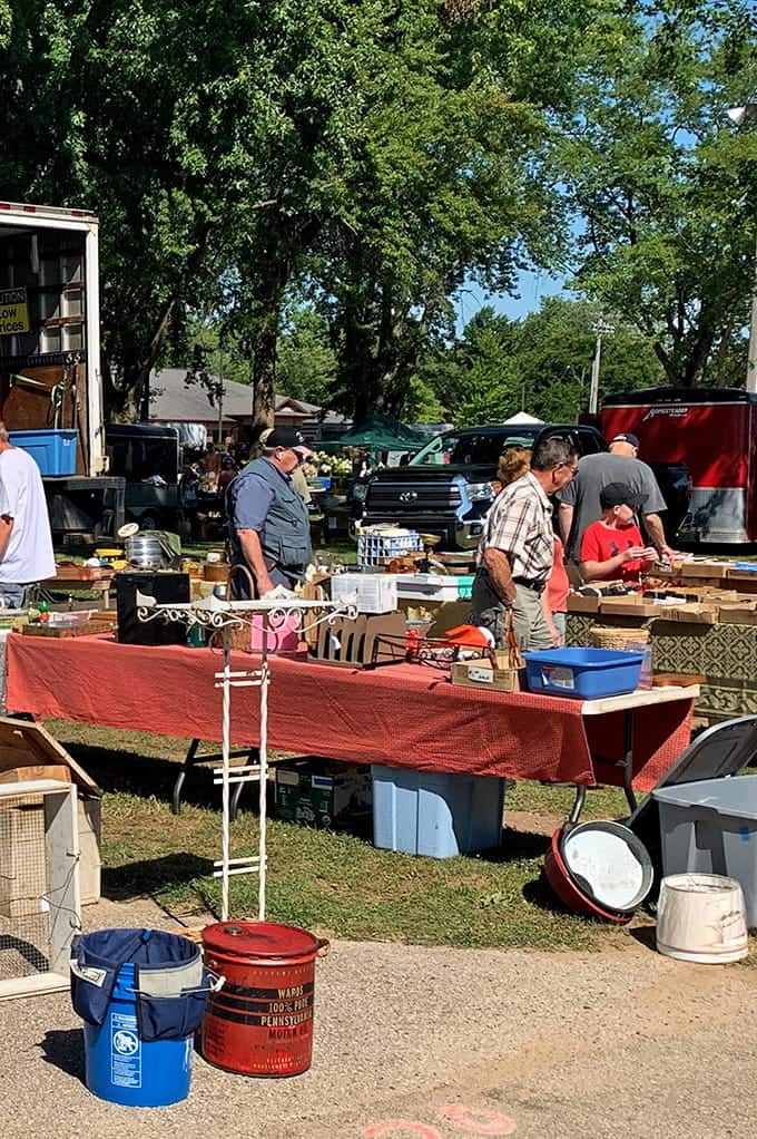 Under leafy trees, vendors display their wares while shoppers hunt for that perfect vintage find nobody else spotted.