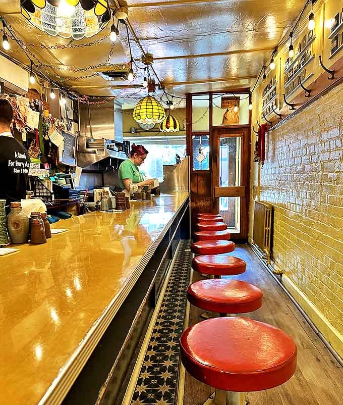 Ten red stools, one golden counter, and enough charm to fill a space ten times this size.