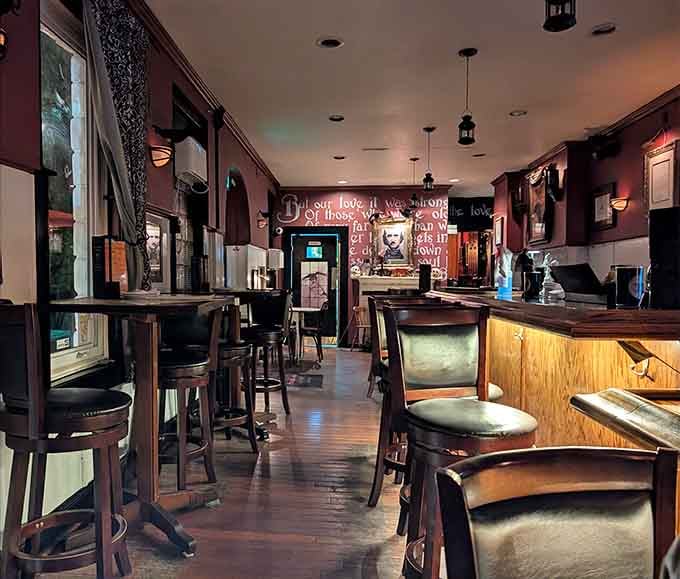 Deep burgundy walls and Poe quotes create an atmosphere where even your salad feels dramatically important.