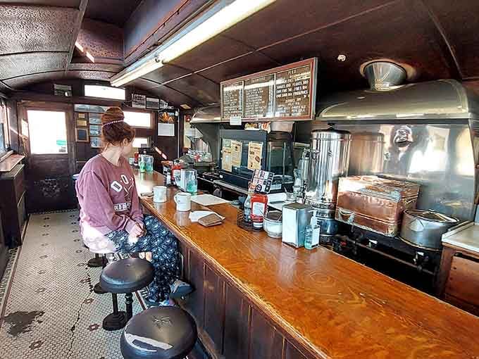 Counter seating where strangers become friends and hot dogs become art, all in a space cozier than your first apartment.