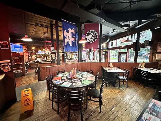 Sports flags, neon signs, and wooden booths create the kind of comfortable chaos where great ribs happen.