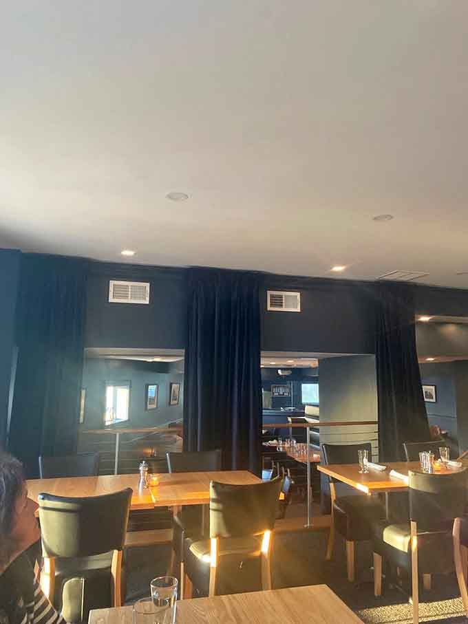 Modern coastal elegance meets comfort food heaven, where blue walls whisper promises of seafood dreams ahead.