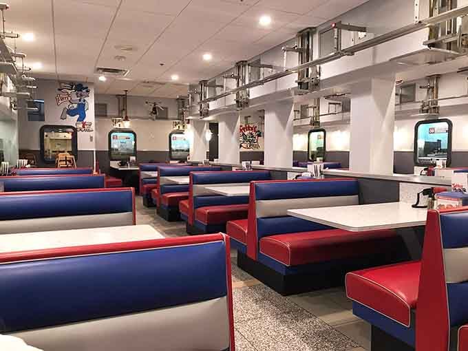 Red and blue booths stretch beneath an overhead railway system that's about to make your lunch infinitely more interesting.
