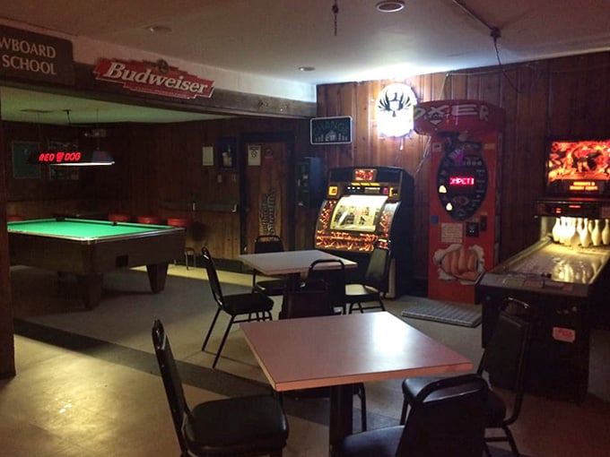 Wood paneling, neon signs, and arcade games: the holy trinity of dive bar perfection in one glorious space.