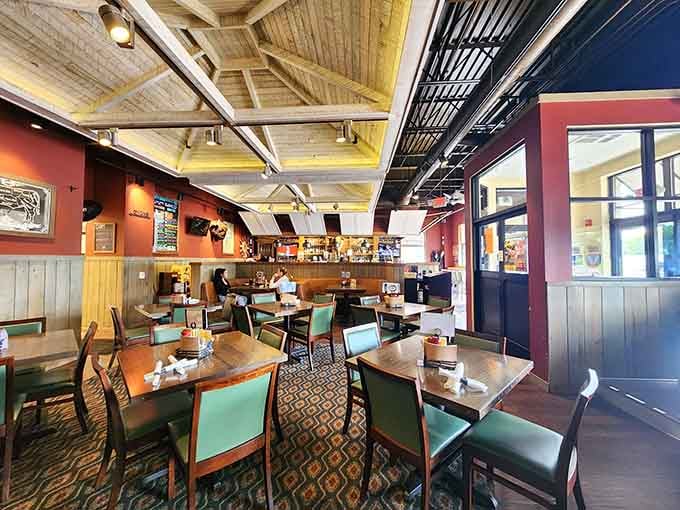 Warm wood tones, mint green chairs, and exposed ceiling beams create that perfect "come as you are, stay as long as you want" vibe.