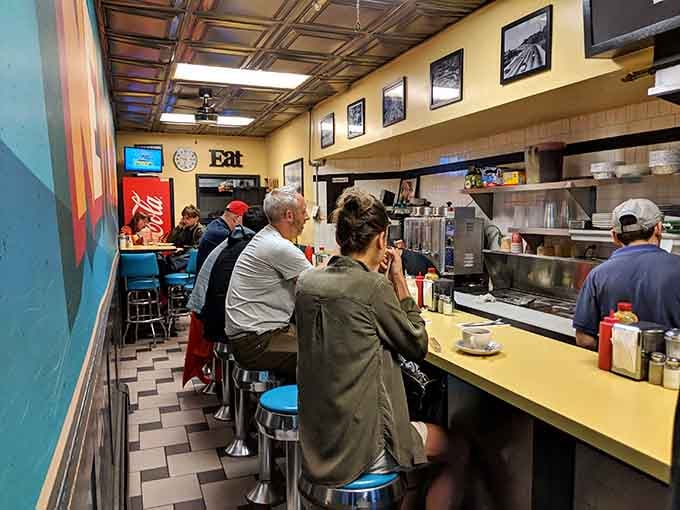 Counter seating where strangers become friends over perfectly cooked eggs and strong coffee.