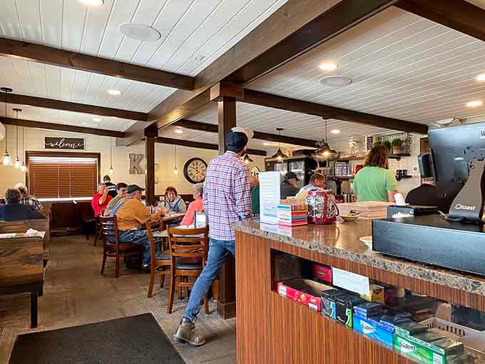 White beadboard ceilings and dark wooden beams create farmhouse charm without feeling like a theme park version of authenticity.