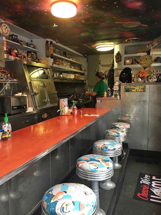 Counter seating under a galaxy ceiling surrounded by toys makes every meal feel like childhood revisited.