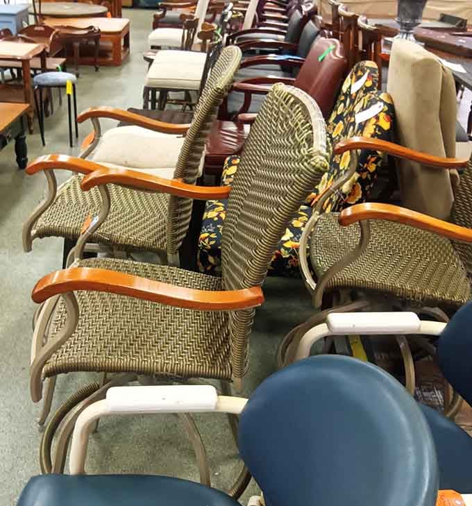 Wicker chairs with wooden arms lined up like they're auditioning for your patio, each one ready for its comeback tour.