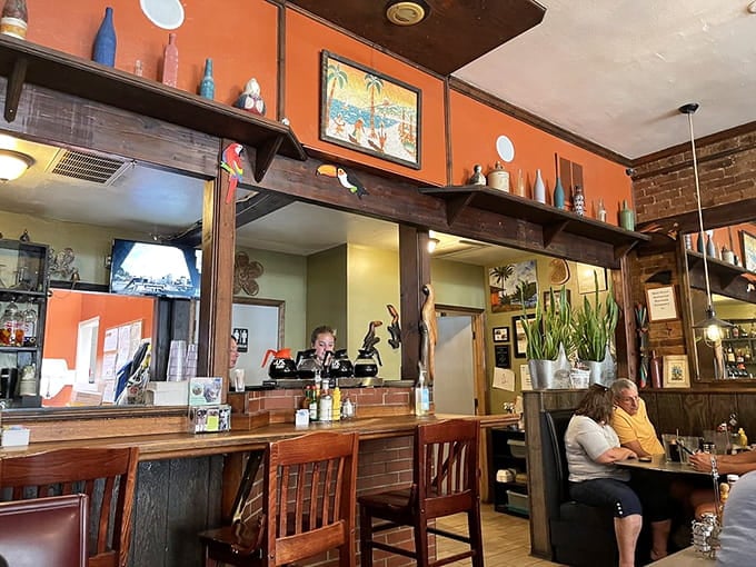 Orange walls and wooden booths create the kind of cozy atmosphere where strangers become friends over hash browns and coffee.