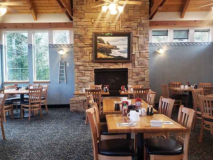 Stone fireplace, wooden beams, and tables ready for serious breakfast business in a dining room built for lingering.
