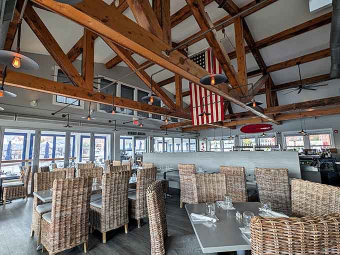 Soaring timber beams and wicker chairs create a space where rustic charm meets waterfront sophistication beautifully.